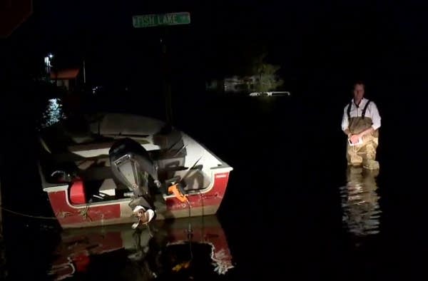 Reporters standing in water | MPR News